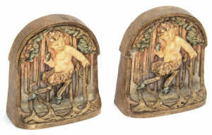 A pair of Compton Pottery bookends, each with rounded tops and modelled ...